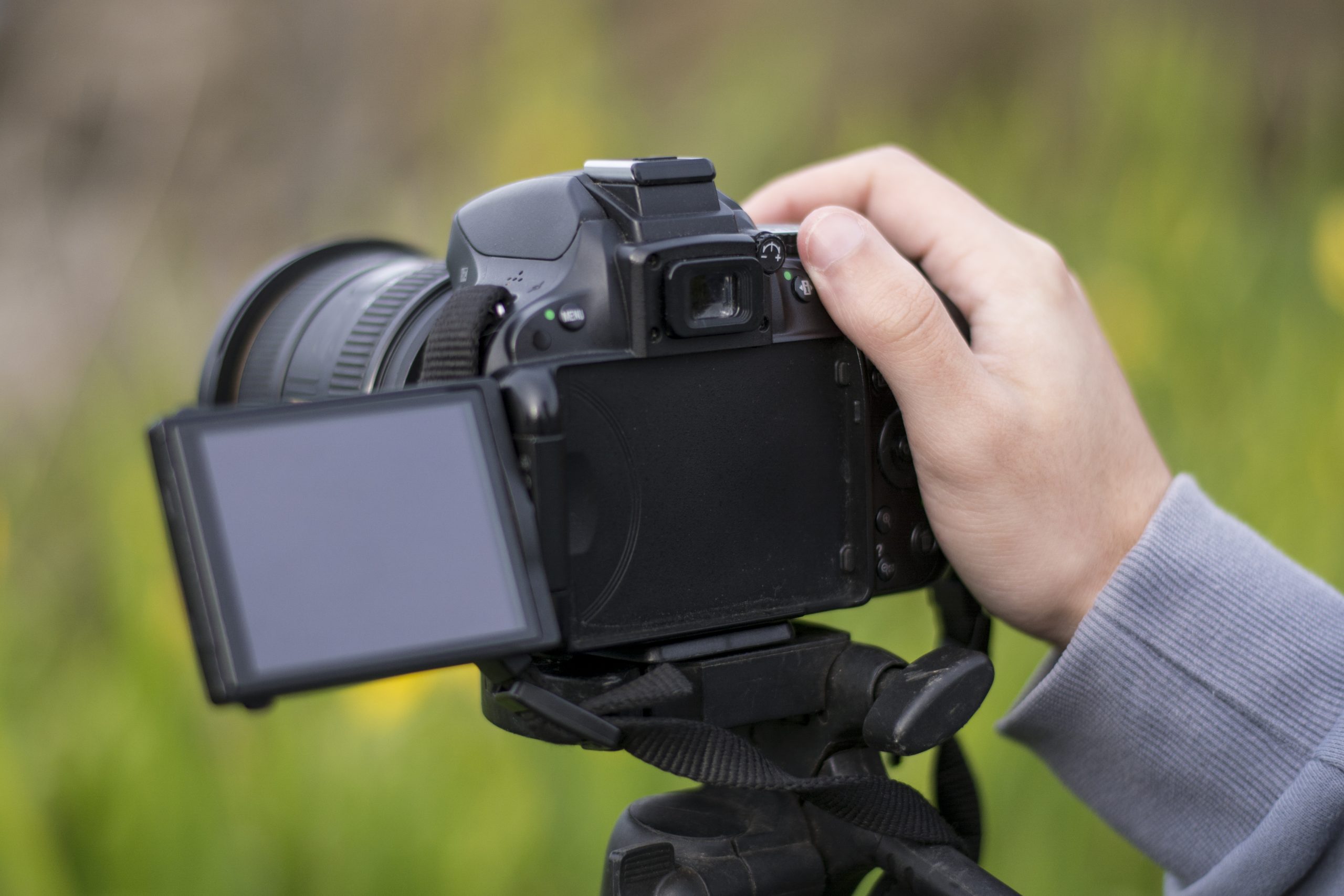 A hand holding a camera